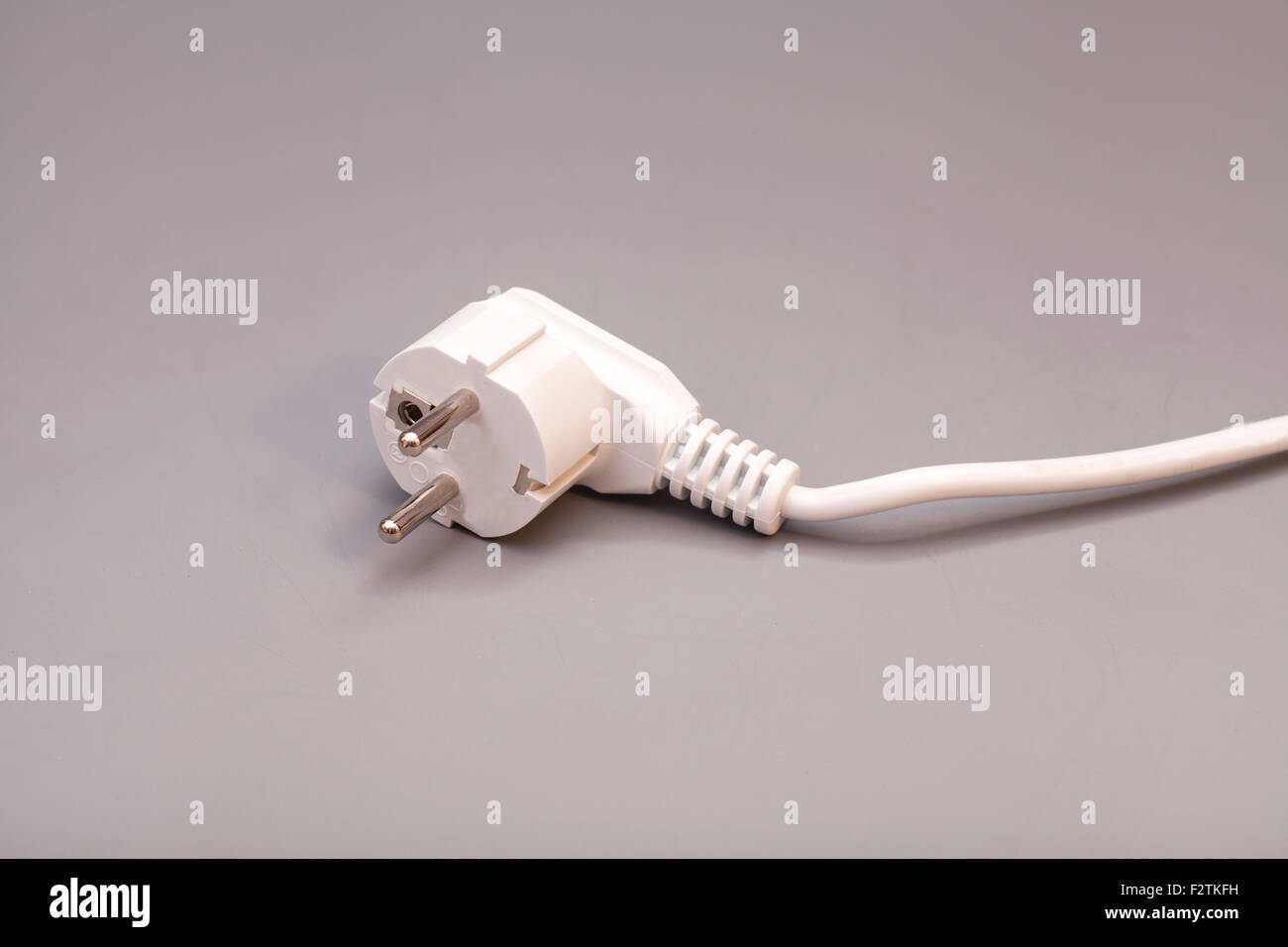 White plug isolated on gray background Stock Photo - Alamy