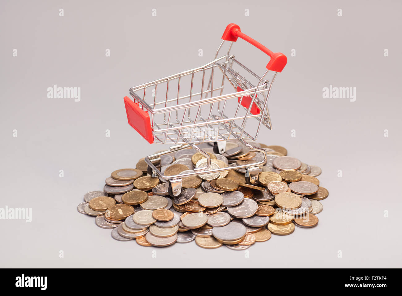 shopping cart with coins isolated on gray background Stock Photo - Alamy