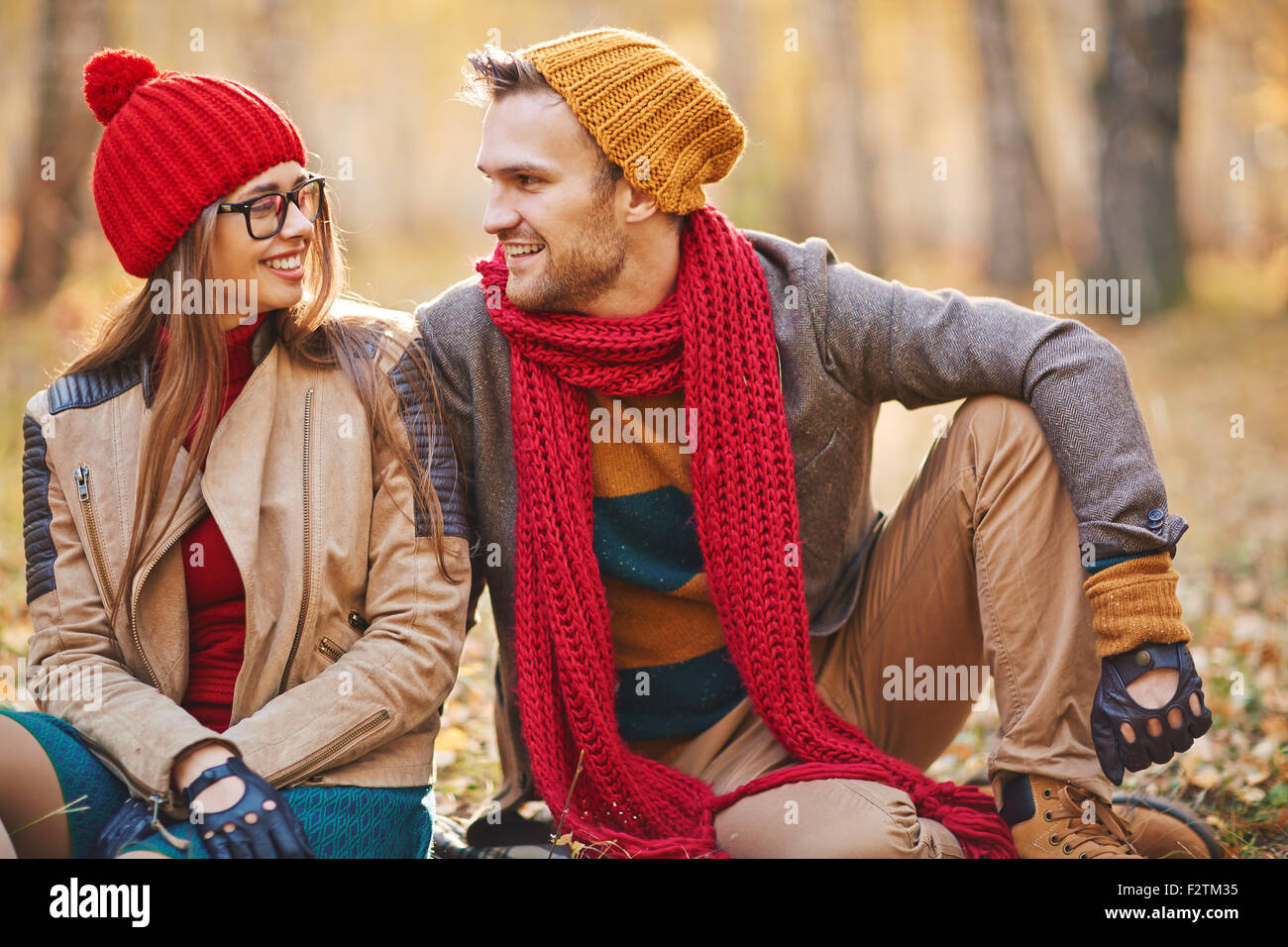 Young dates looking at one another while relaxing in park Stock Photo ...