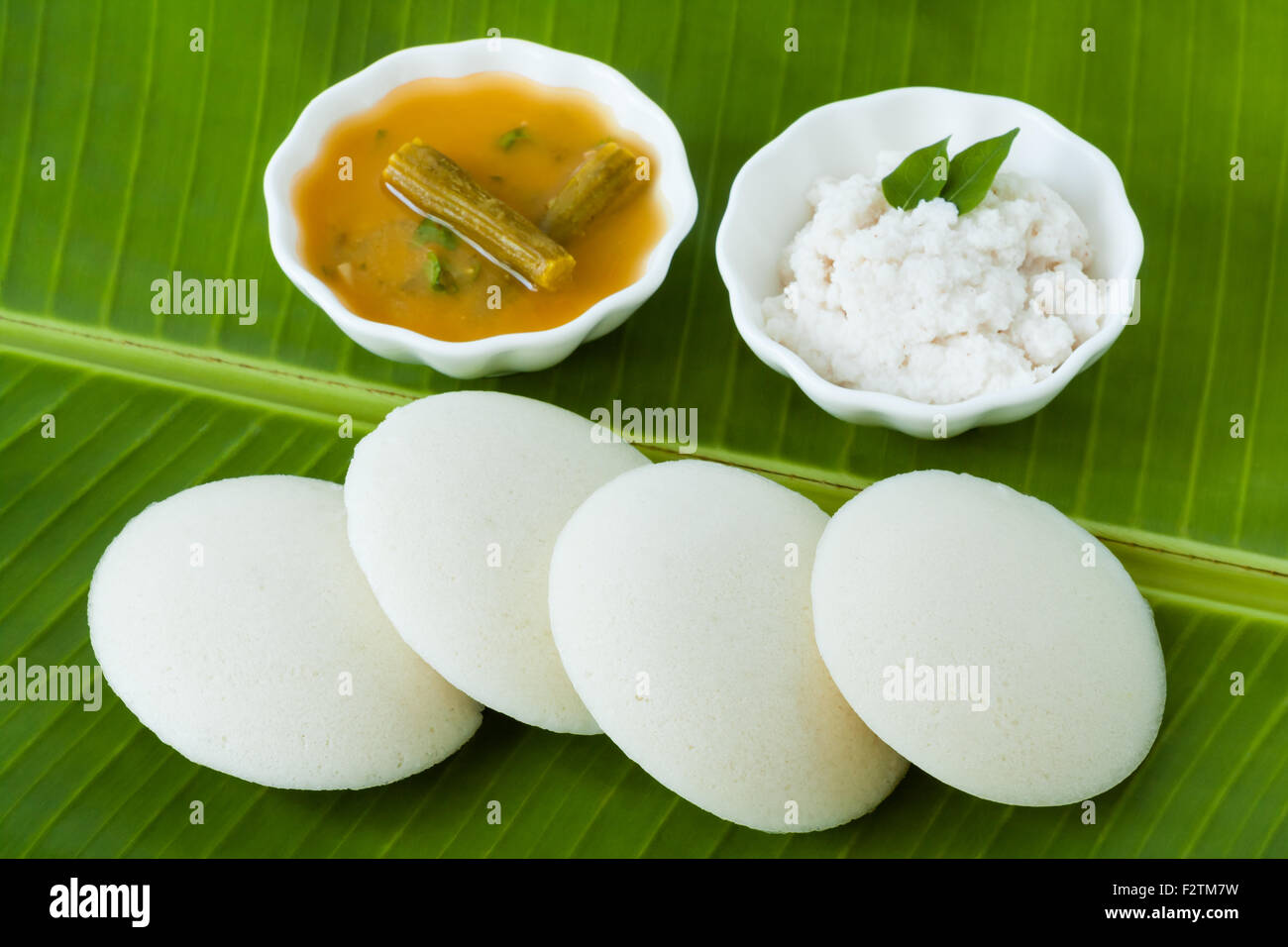 Fresh steamed Indian Idly (Idli / rice cake) arranged on a traditional ...