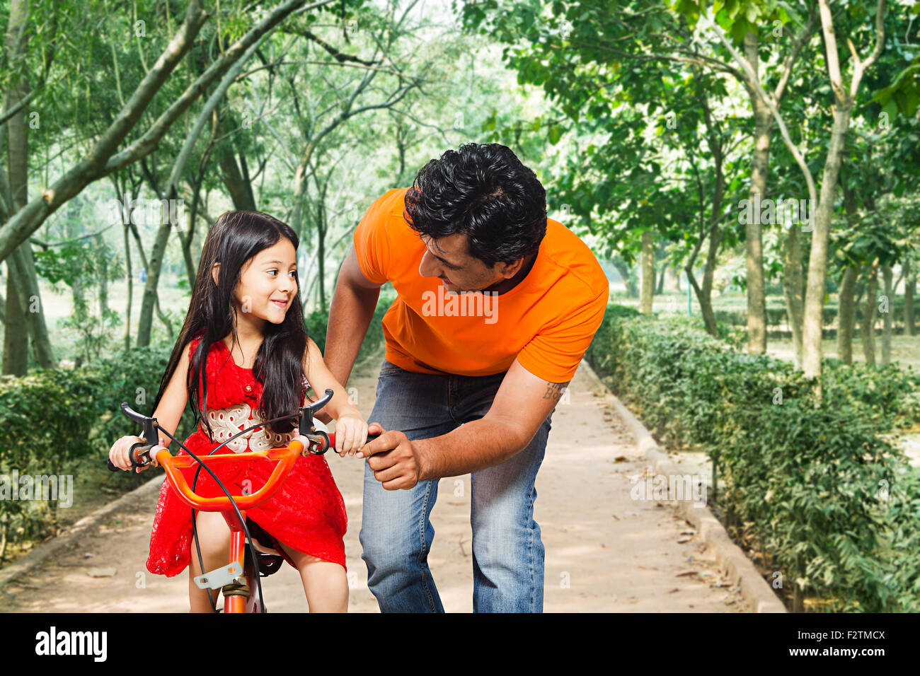 2 indian Father and Kids Daughter park Riding Bicycle Stock Photo - Alamy