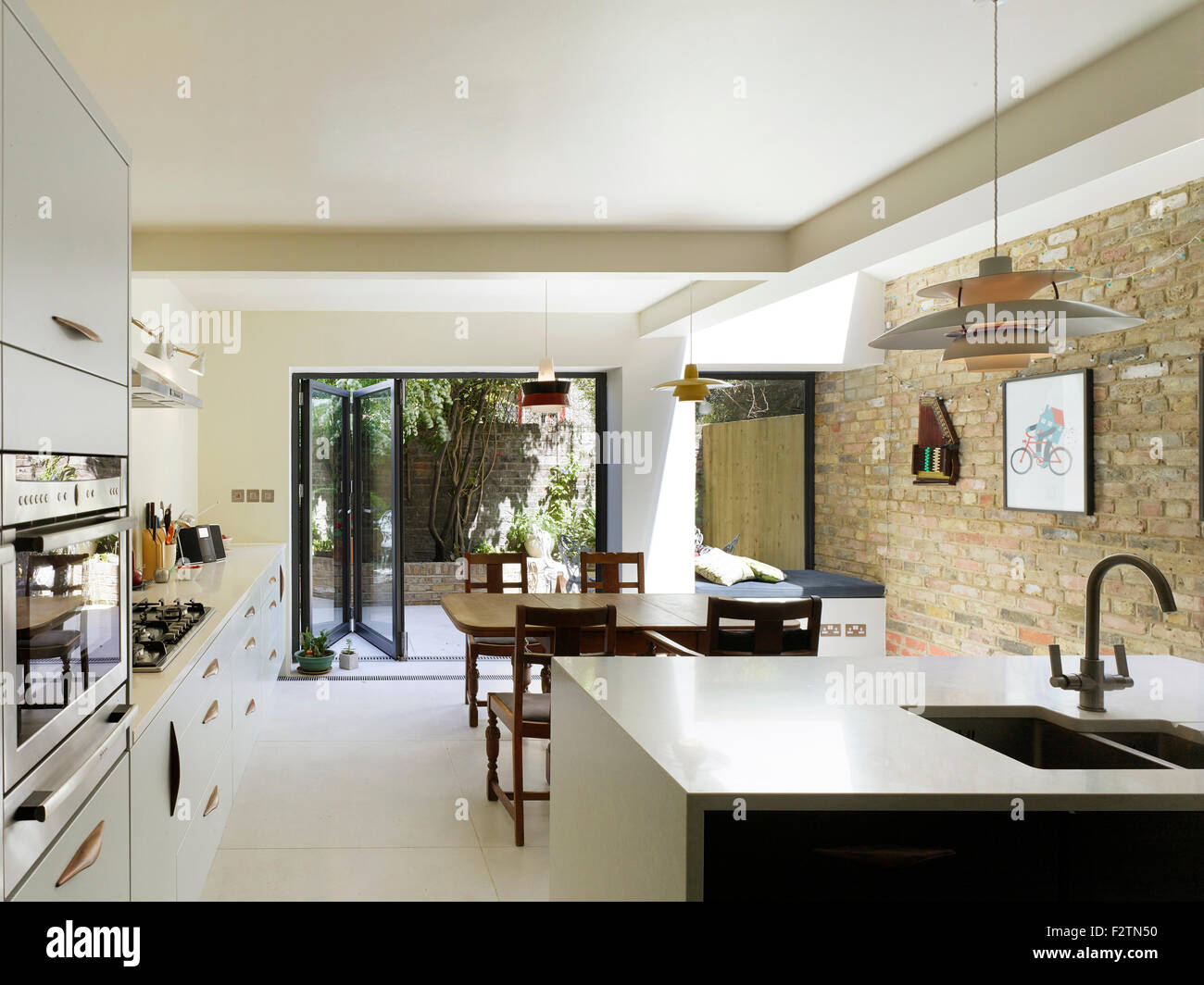 Modern kitchen with exposed brickwork and concertina door. Princess May ...