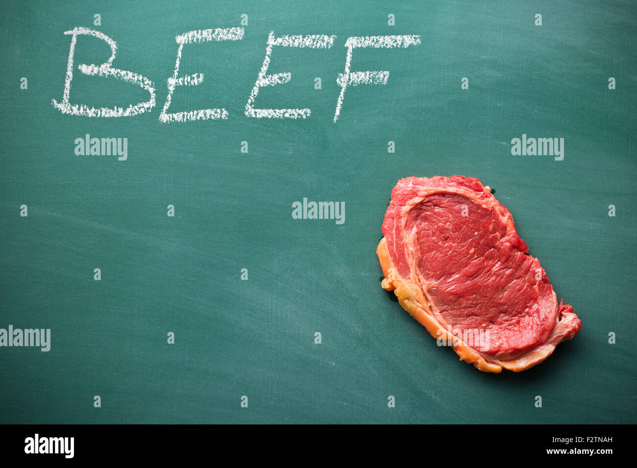 fresh raw beef on chalkboard Stock Photo - Alamy