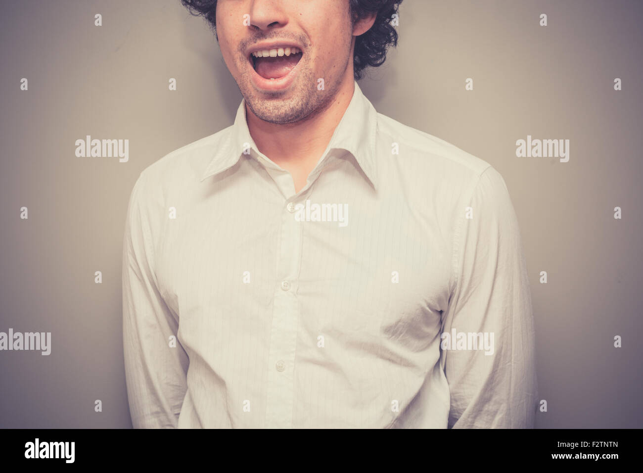 Smiling young man is standing around in a white shirt Stock Photo - Alamy