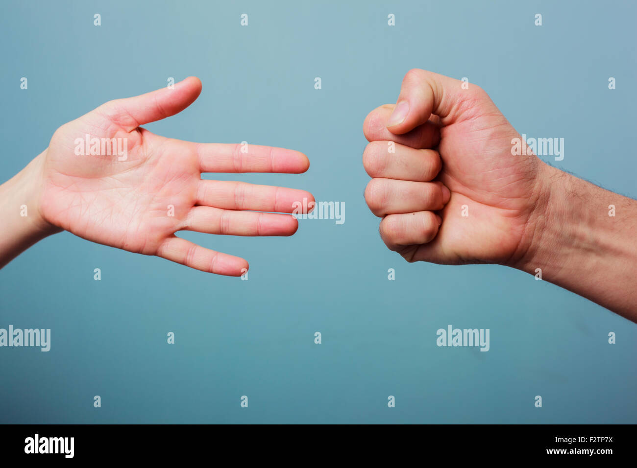 Young man and woman are playing rock paper scissors Stock Photo - Alamy