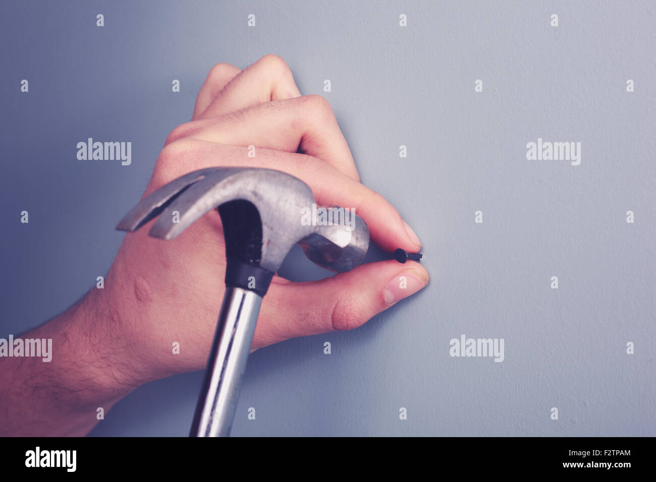 Hand holding hammer nail hi-res stock photography and images - Alamy