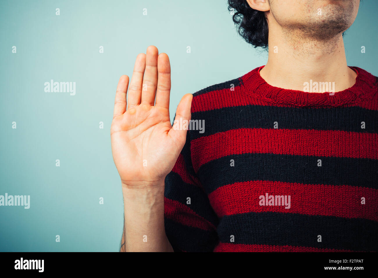 Young ethnic man is pledging allegiance with his right hand raised ...