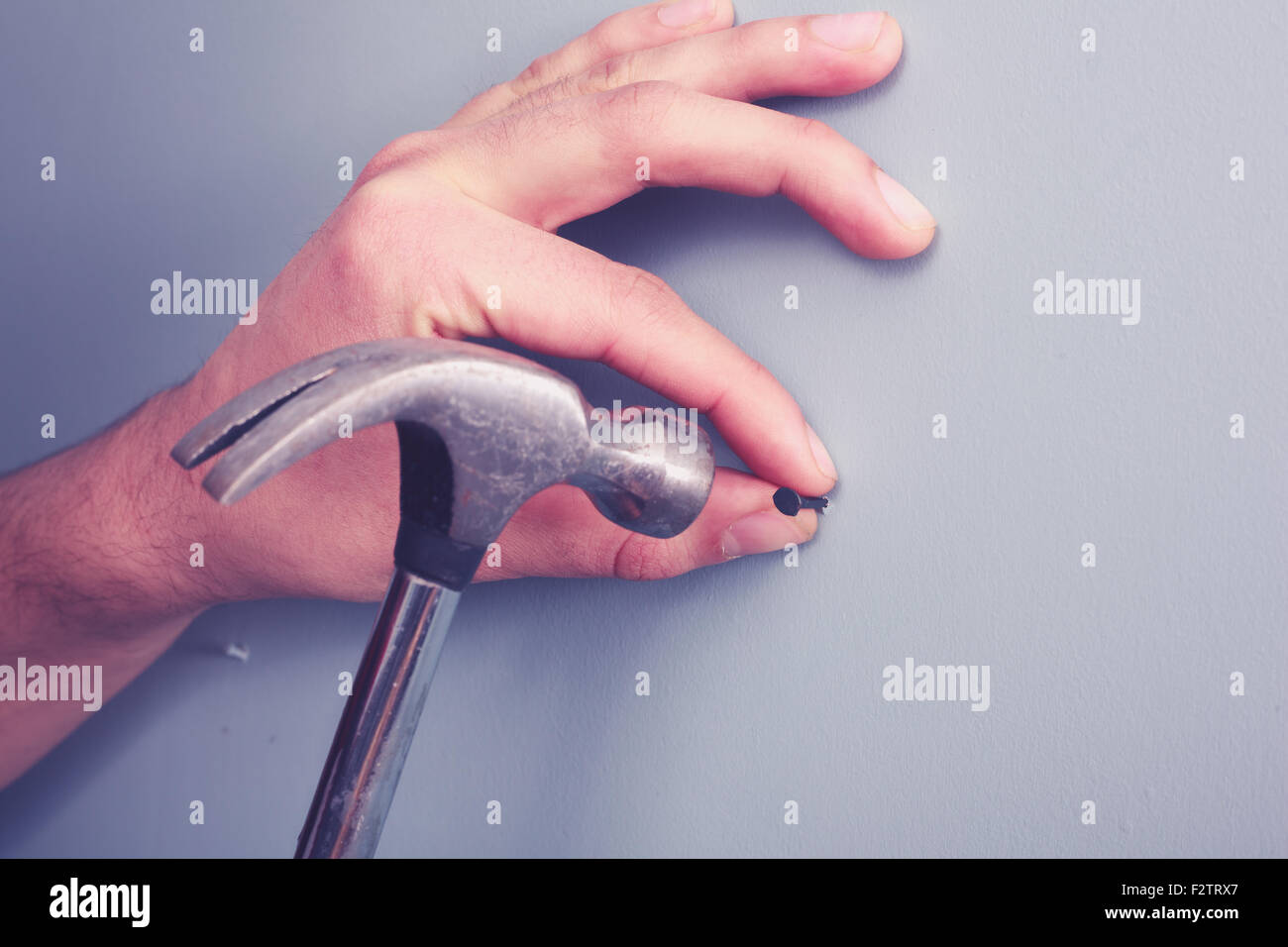 Hand holding hammer nail hi-res stock photography and images - Alamy
