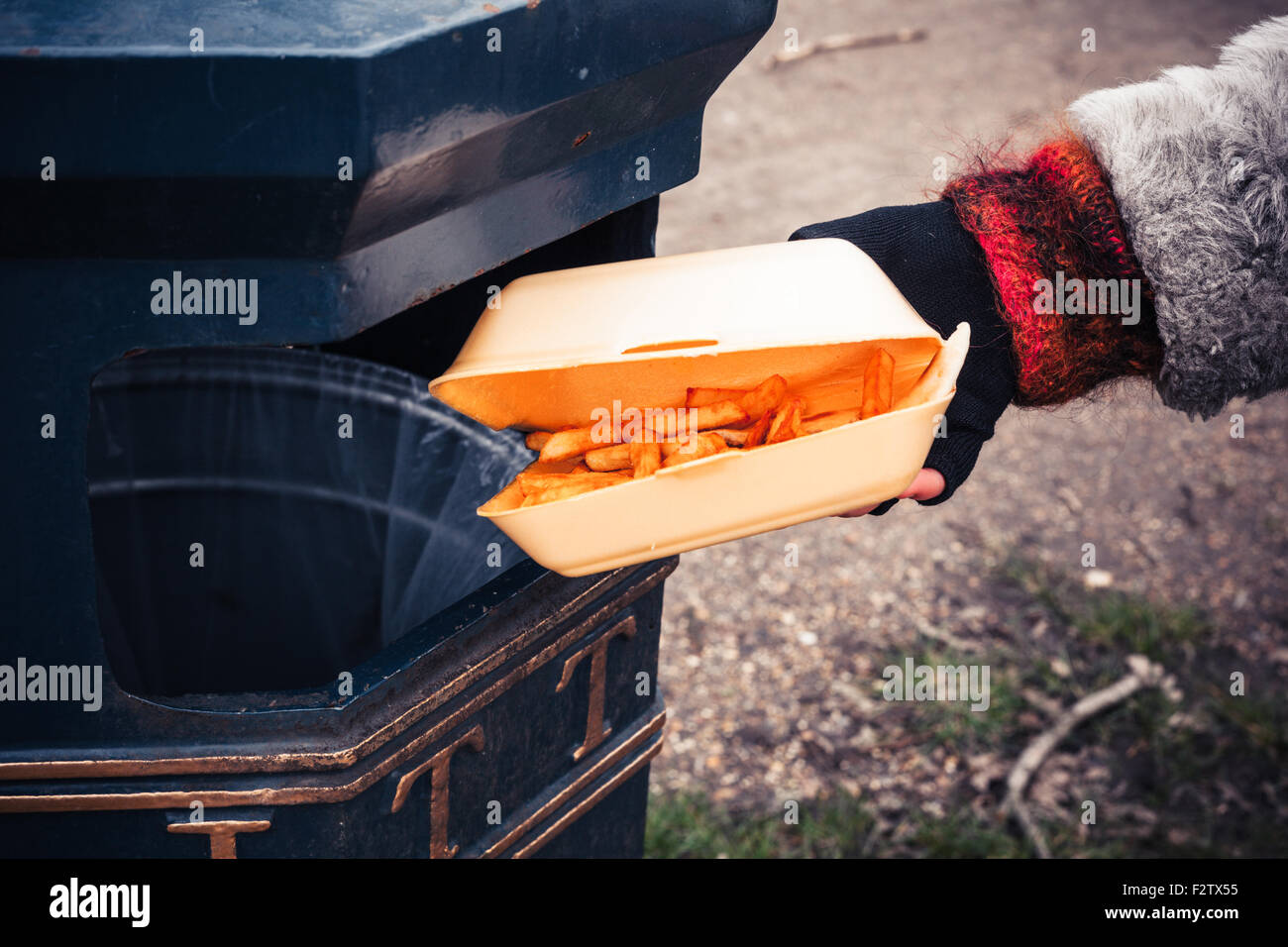 Closeup on a hand putting a box of chips in the bin Stock Photo - Alamy