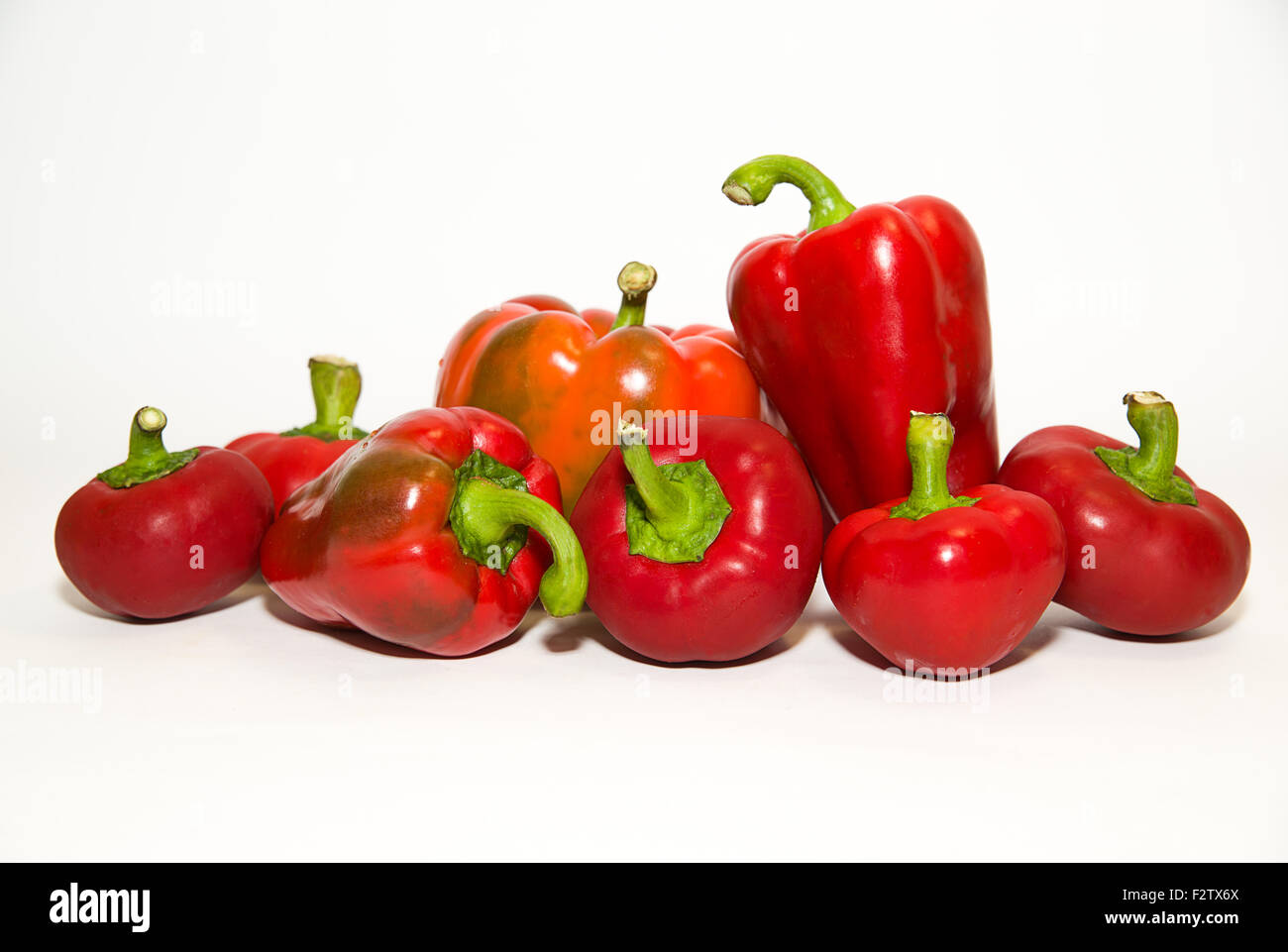 Many red peppers on a white background Stock Photo - Alamy