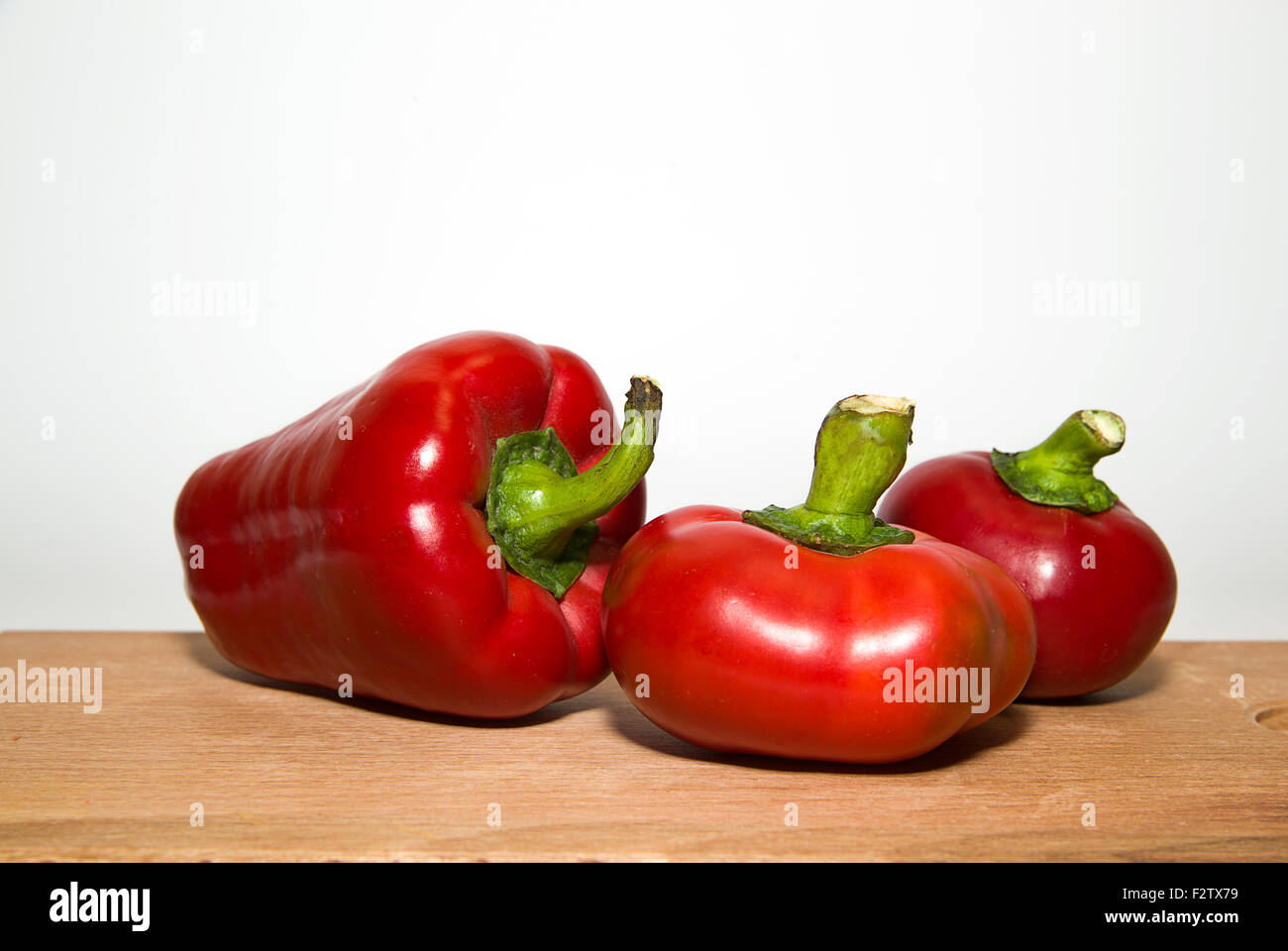 Three red peppers on a white background Stock Photo - Alamy