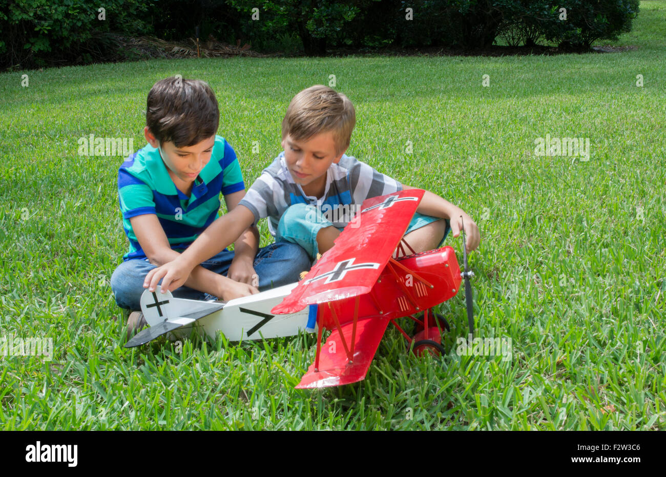Two young boys playing with a model plane German Fokker DII from WWI in ...