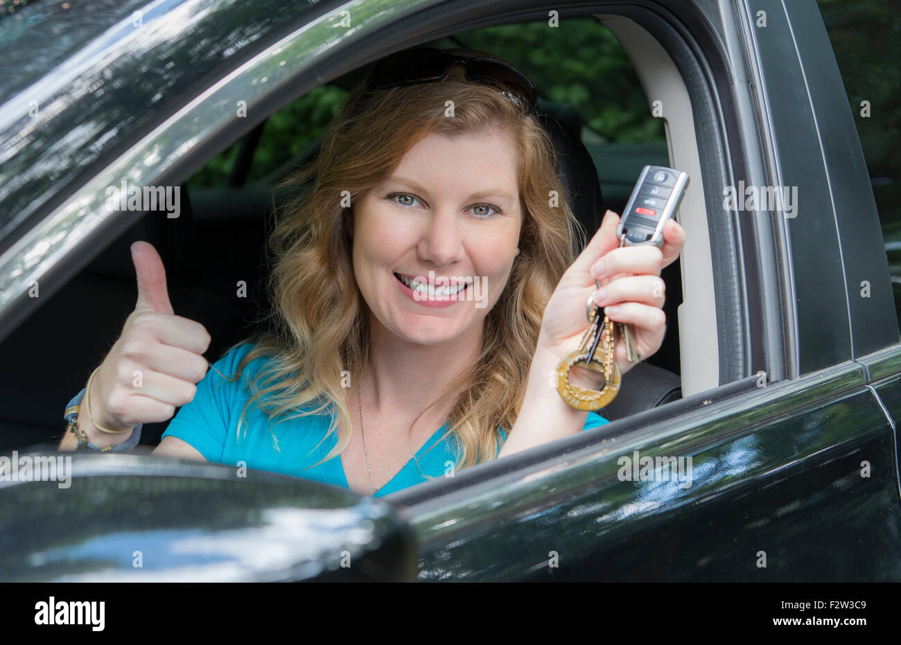 Young teenage girl age 16 with first driving of a car showing off her ...