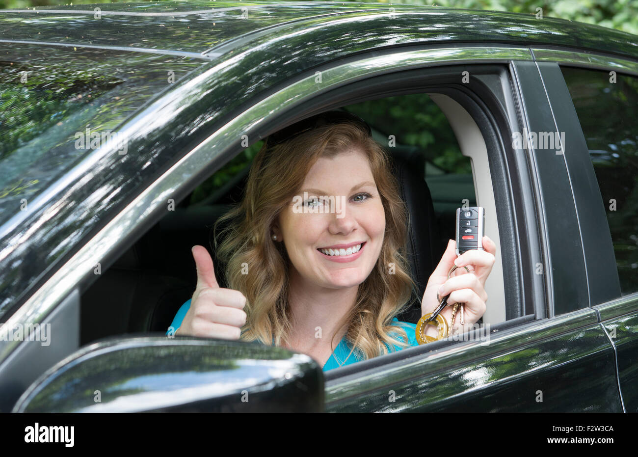 Young teenage girl age 16 with first driving of a car showing off her ...