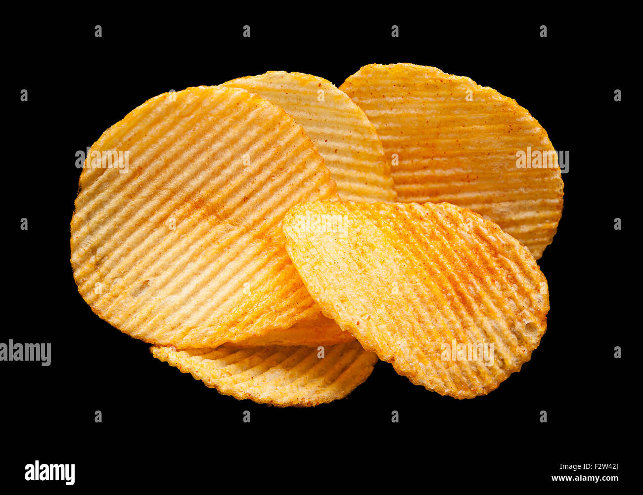 Potato ripple chips snack isolated on black background Stock Photo - Alamy