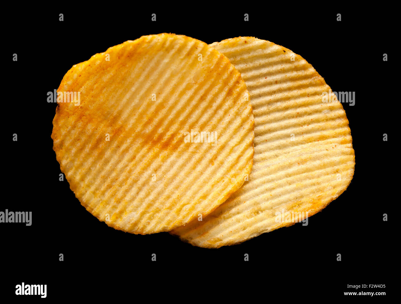 Potato ripple chips snack isolated on black background Stock Photo - Alamy