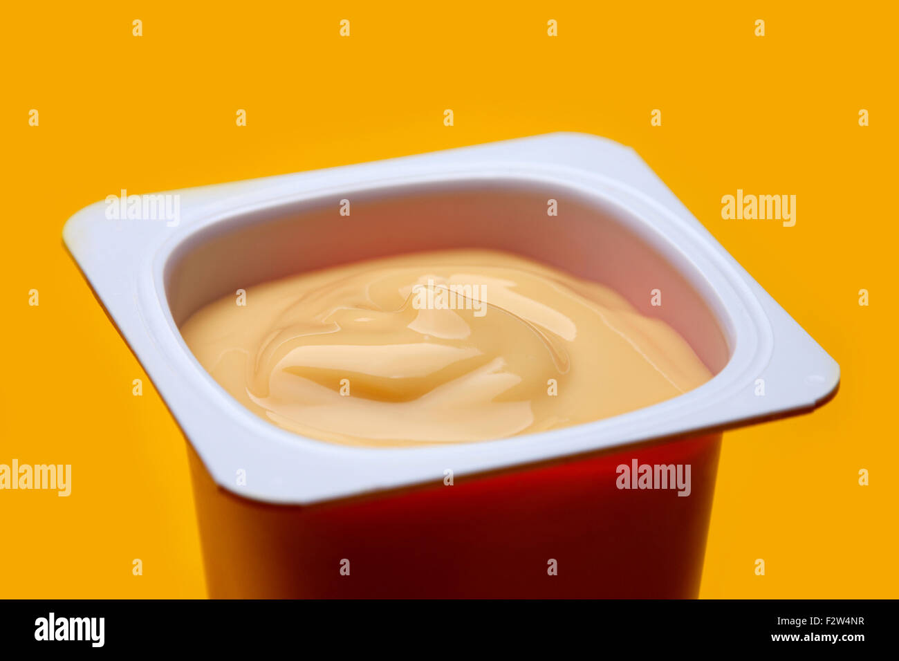 Caramel yogurt in brown plastic box on yellow background Stock Photo ...