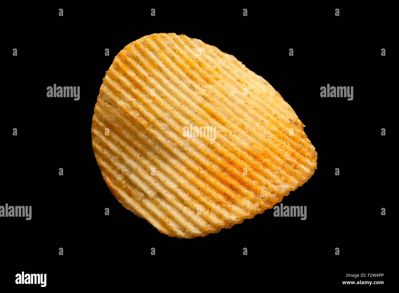 Potato ripple chips snack isolated on black background Stock Photo - Alamy