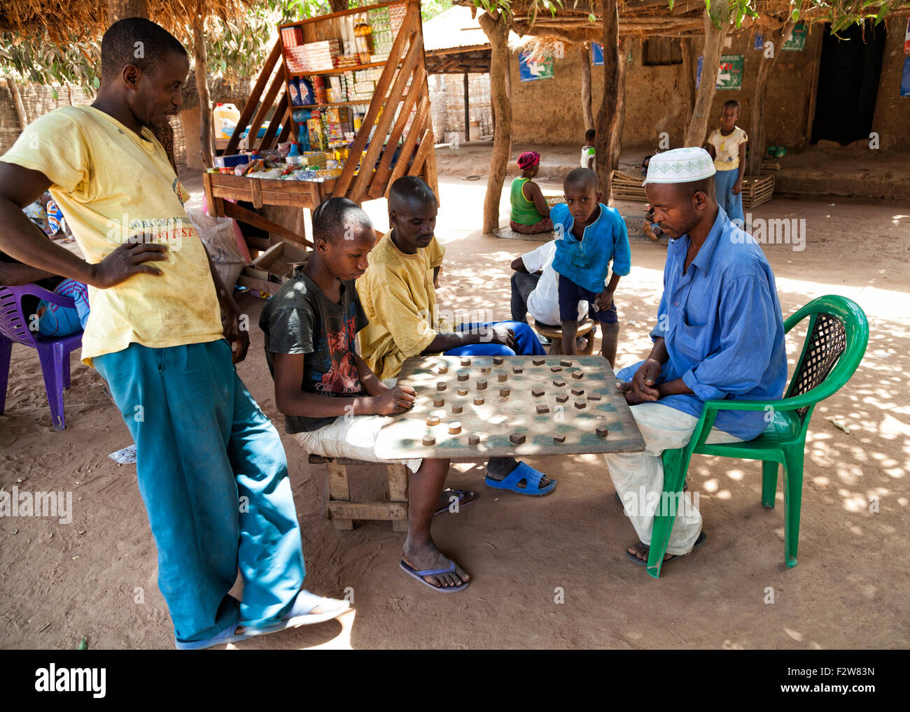 African villagers, adults and youngsters playing checkers on the ...