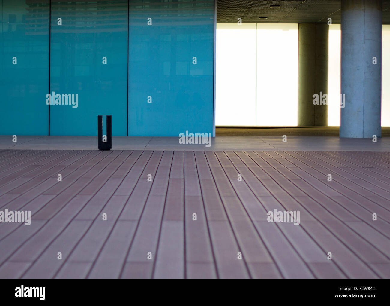 Wood floor with turquoise, modern office windows at the background ...