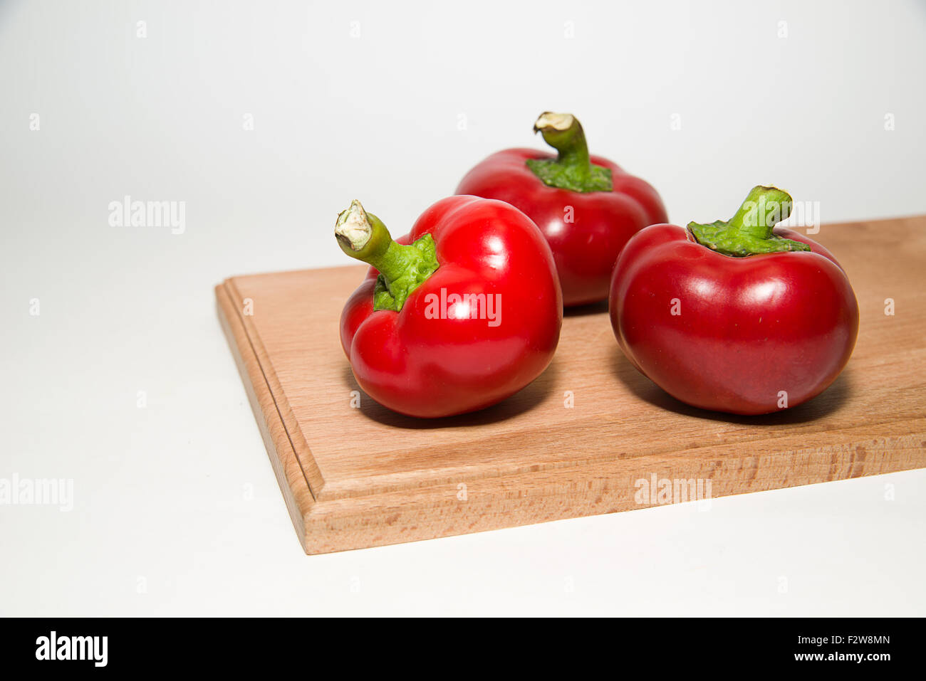 Three red peppers on a white background Stock Photo - Alamy
