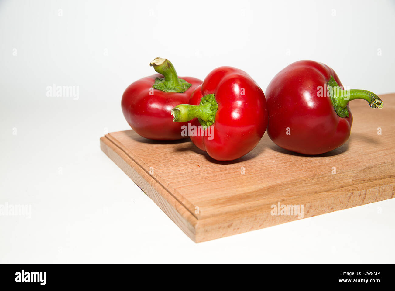 Three red peppers on a white background Stock Photo - Alamy