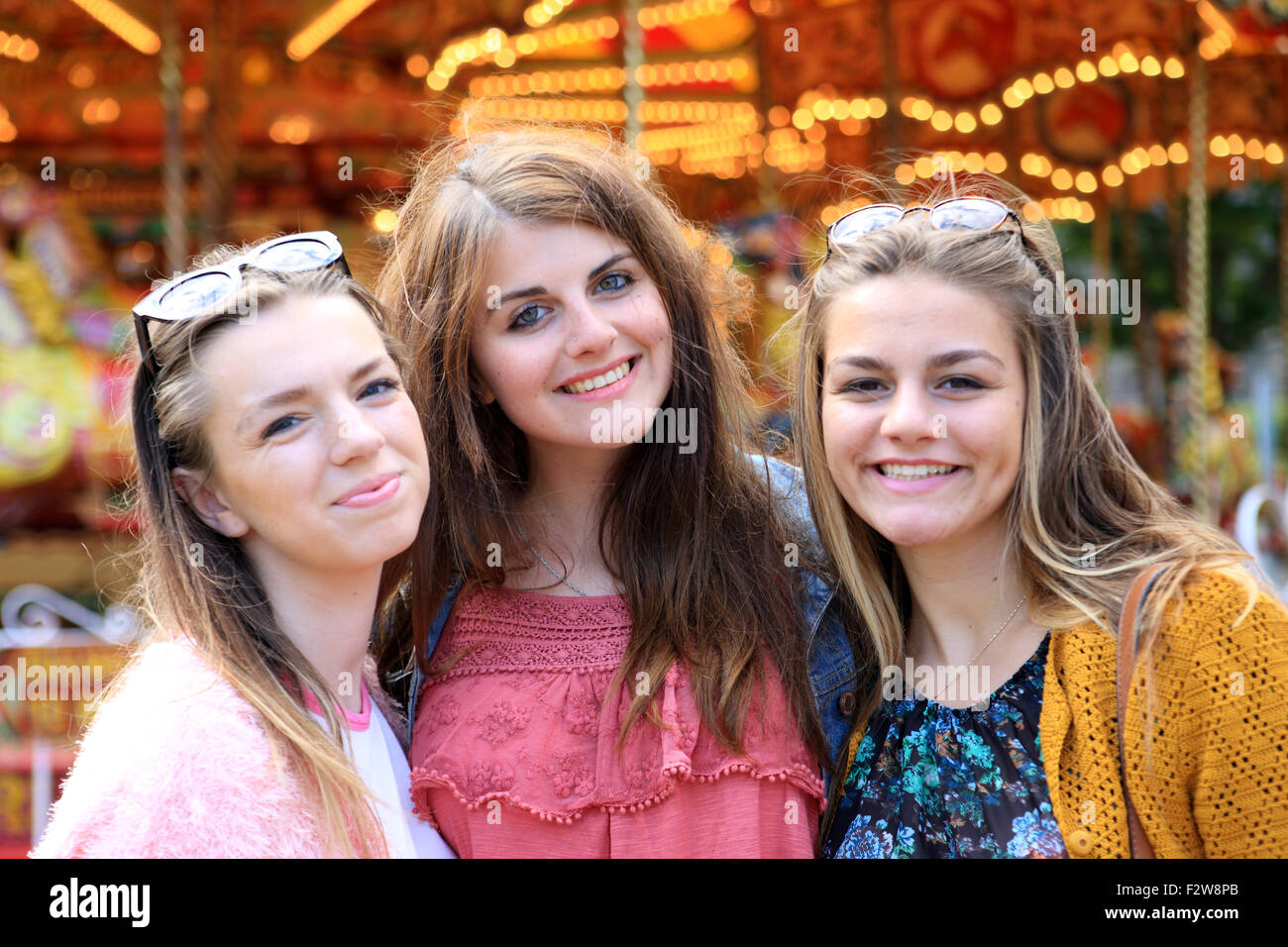 Friends in front of a carousel Stock Photo - Alamy