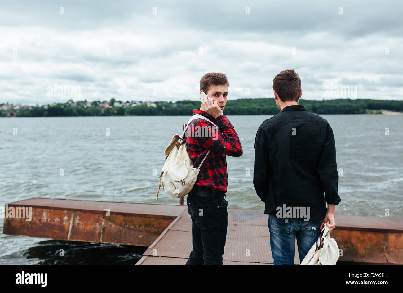two young guys stand on the pier Stock Photo - Alamy