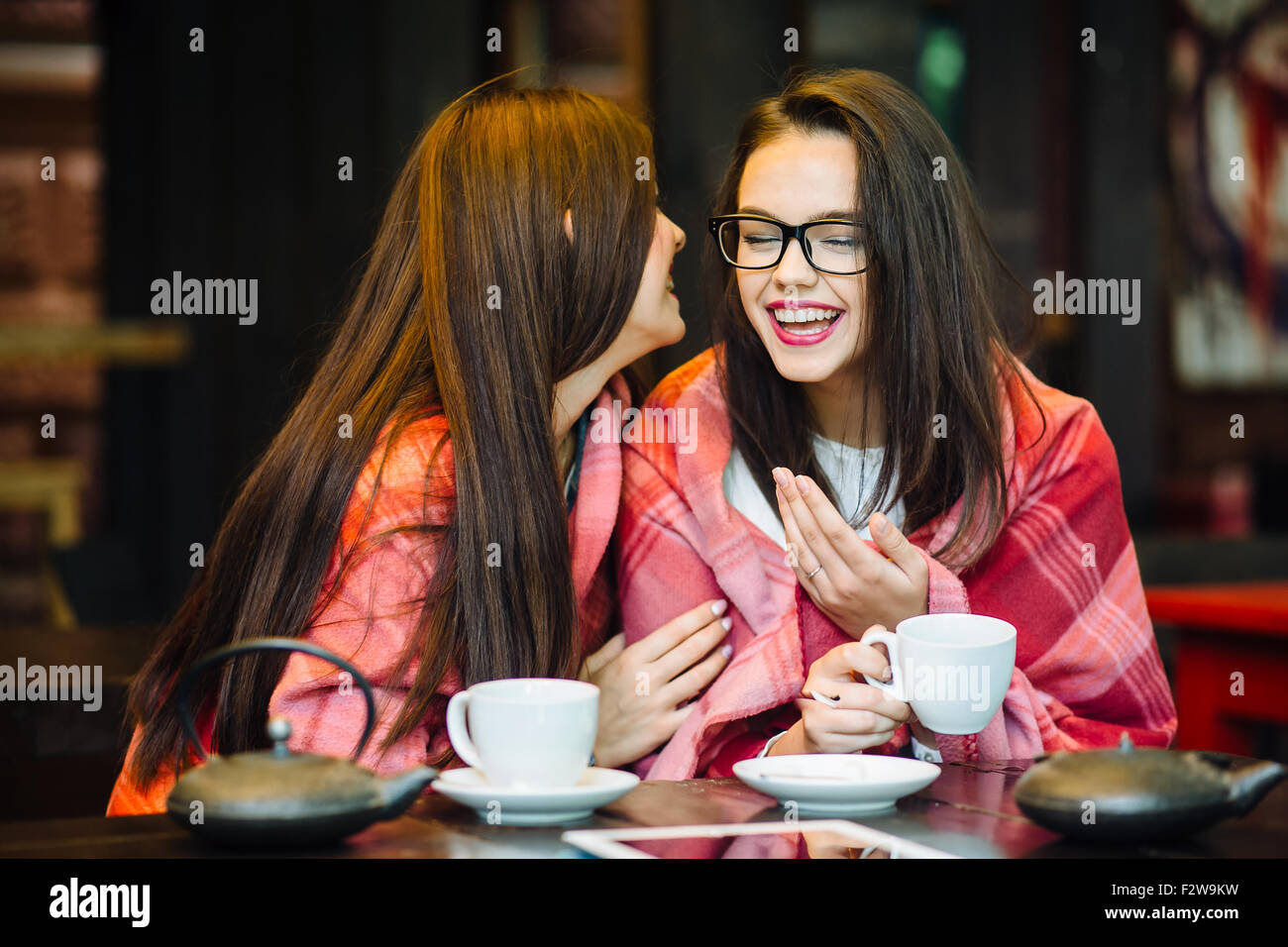 Two young and beautiful girls gossiping Stock Photo - Alamy