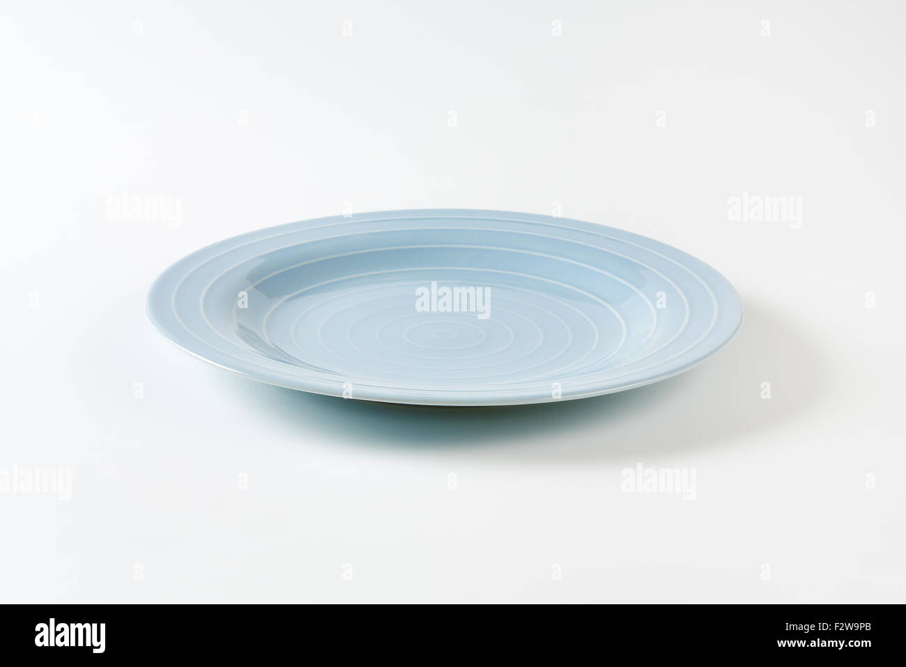 empty blue plate on white background Stock Photo - Alamy