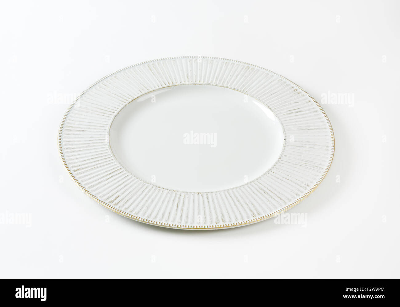 white plate with gold fluted rim on white background Stock Photo - Alamy