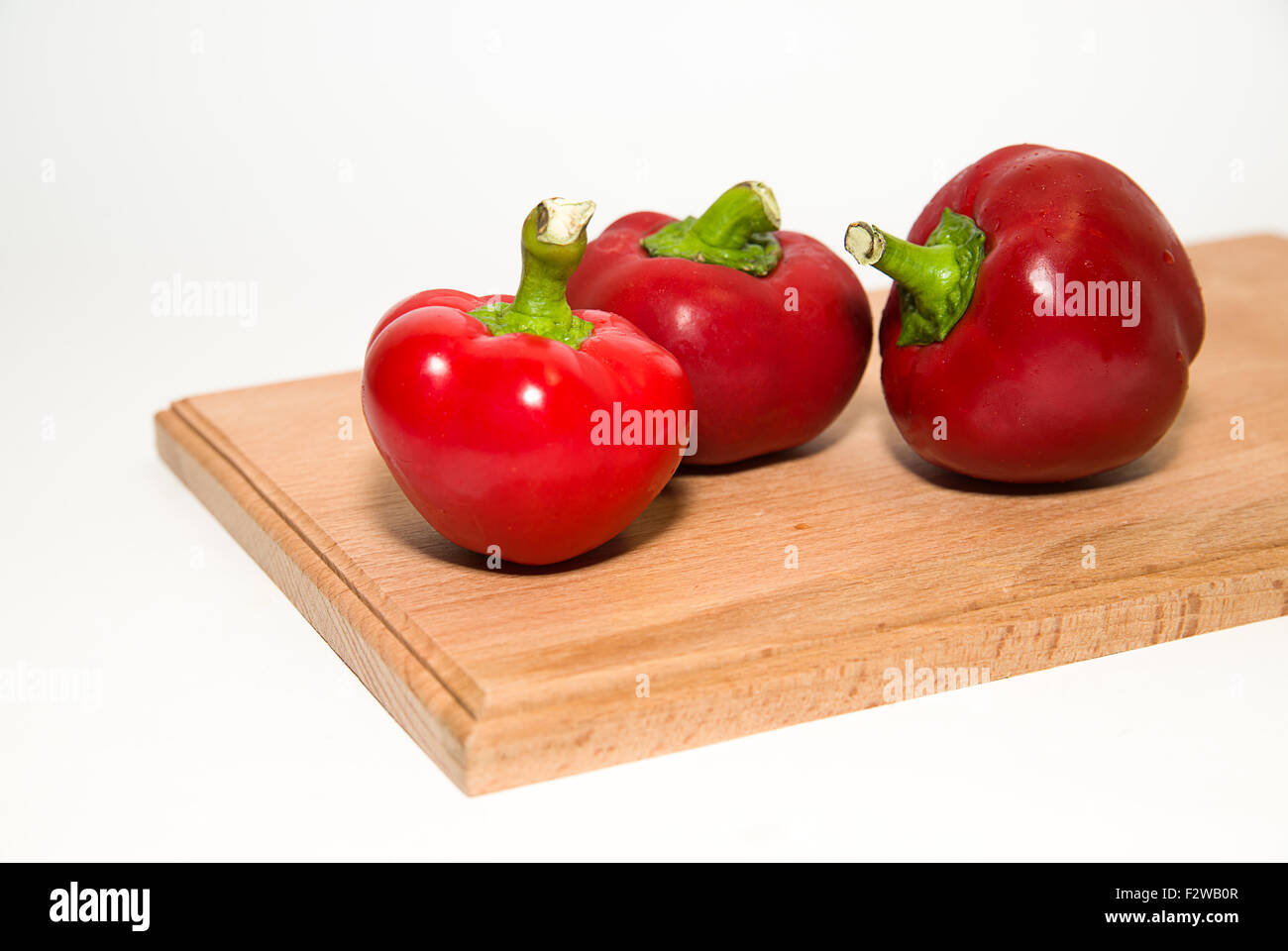 Three red peppers on a white background Stock Photo - Alamy