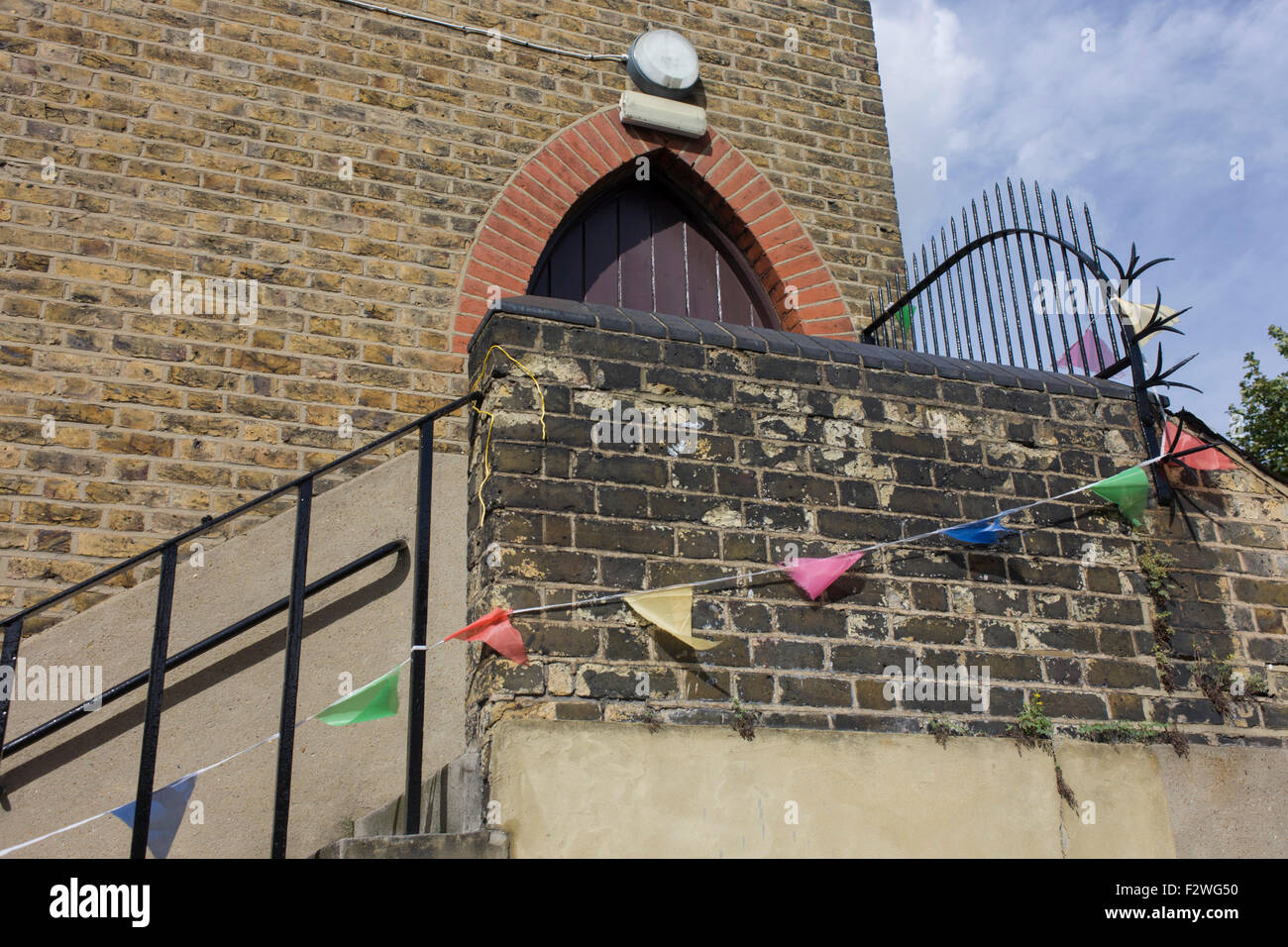 Fading bunting strung along the wall of a local church side entrance in ...