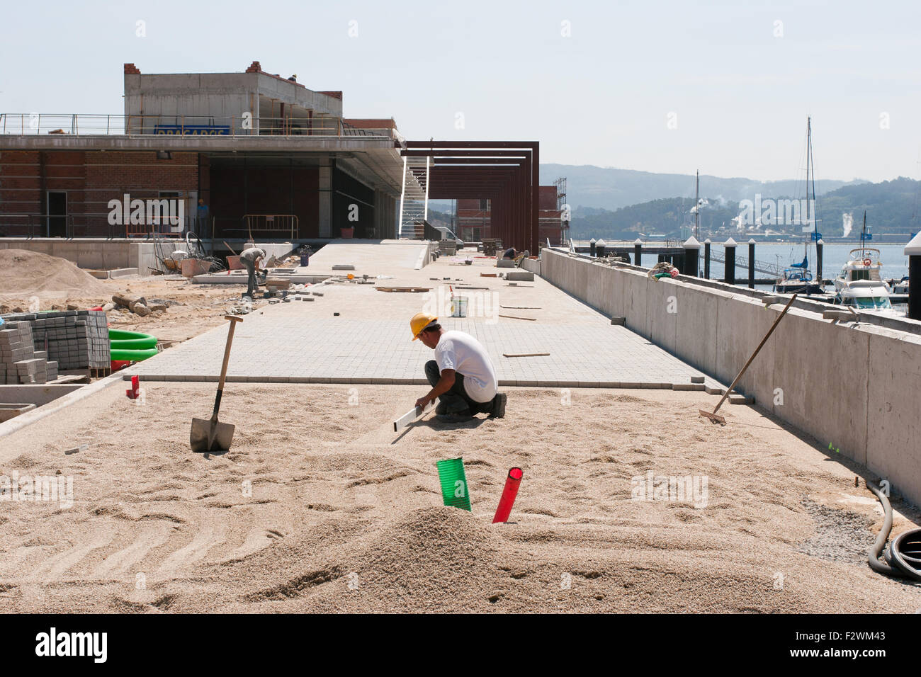 Builder worker at construction site with level Stock Photo - Alamy