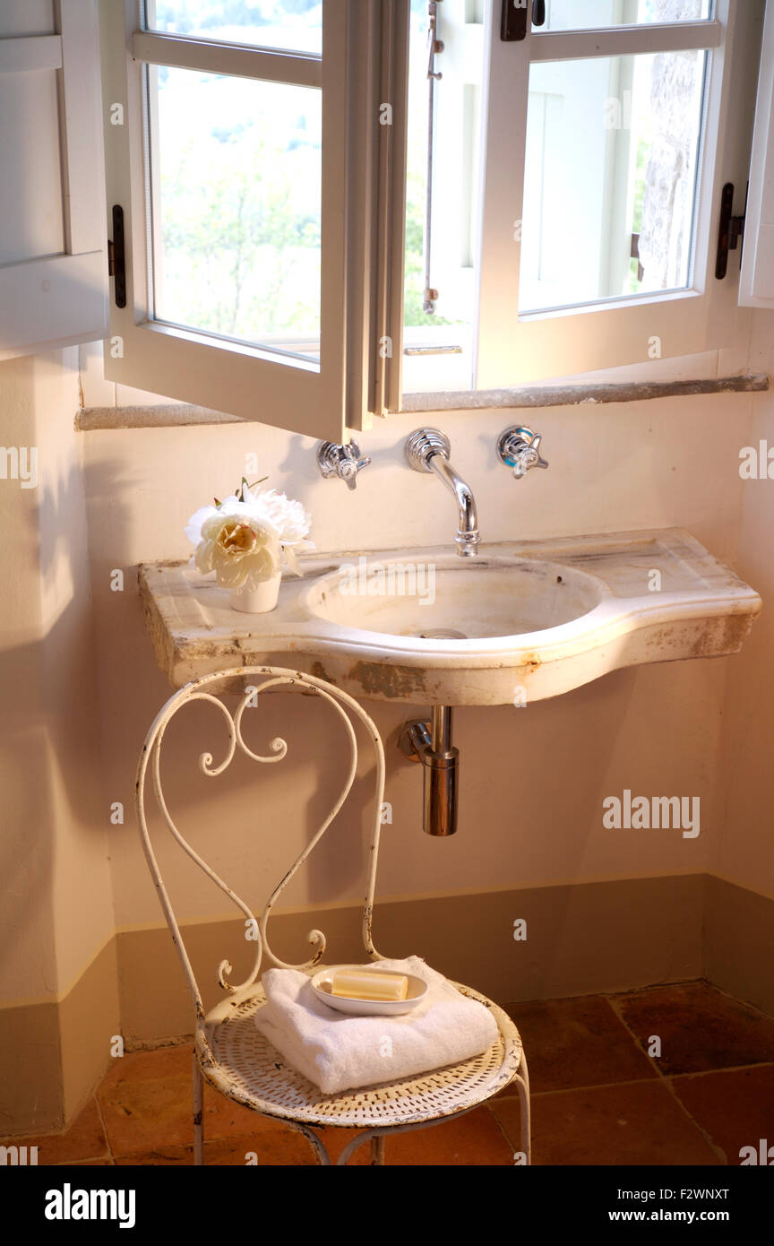 Open windows above small wall mounted basin in Italian country bathroom ...