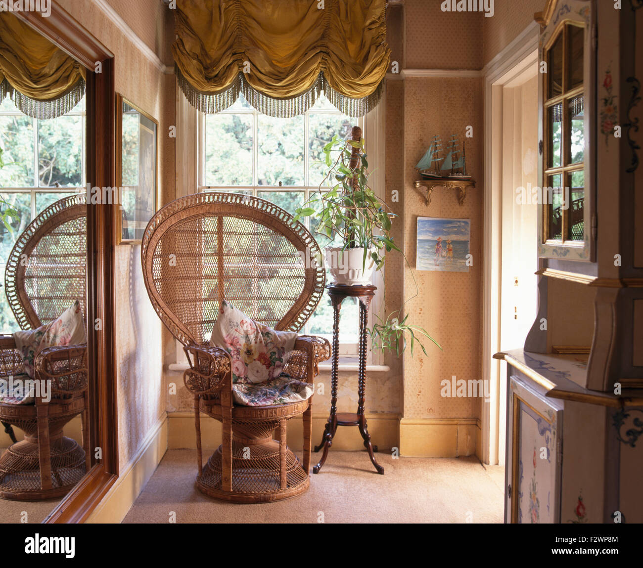Wicker peacock chair against window with festoon blind on nineties ...