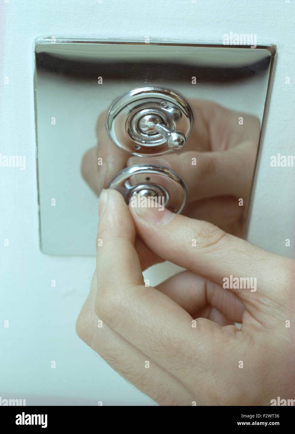 Close-up of a hand on a stainless steel electric light switch Stock ...