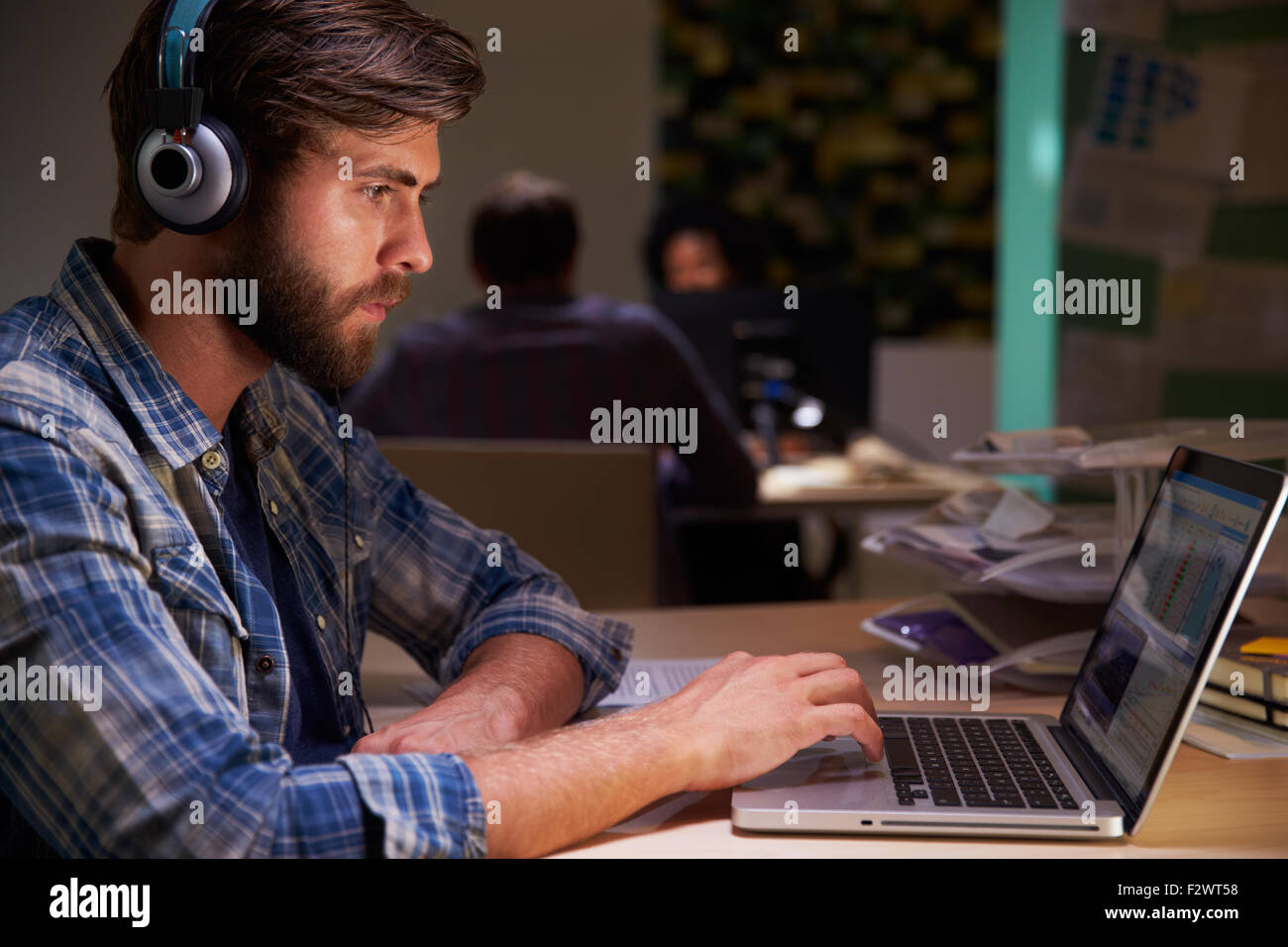 Woman listening music working late hi-res stock photography and images ...
