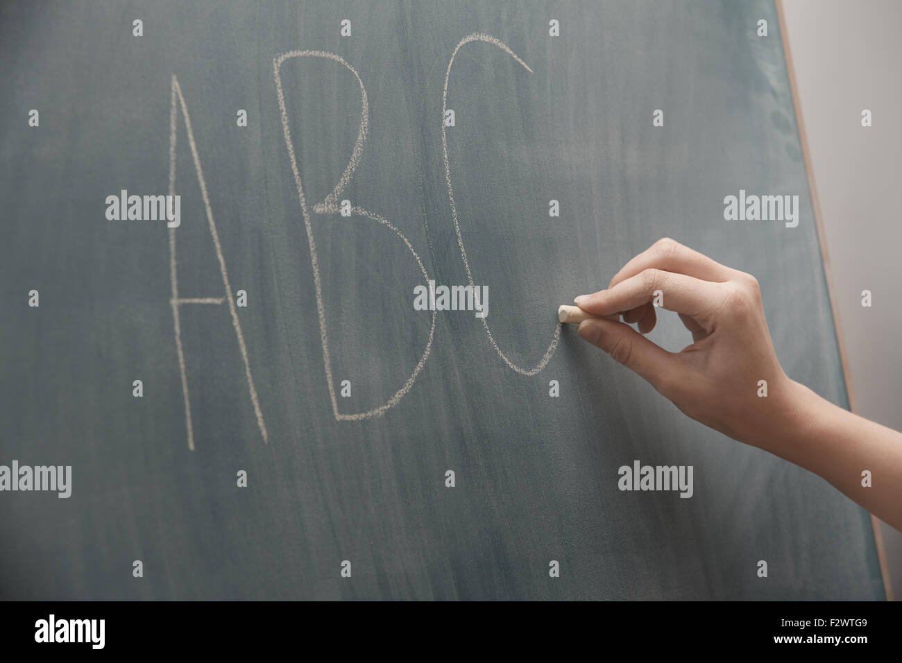 Human hand writing ABC characters on a blackboard Stock Photo - Alamy