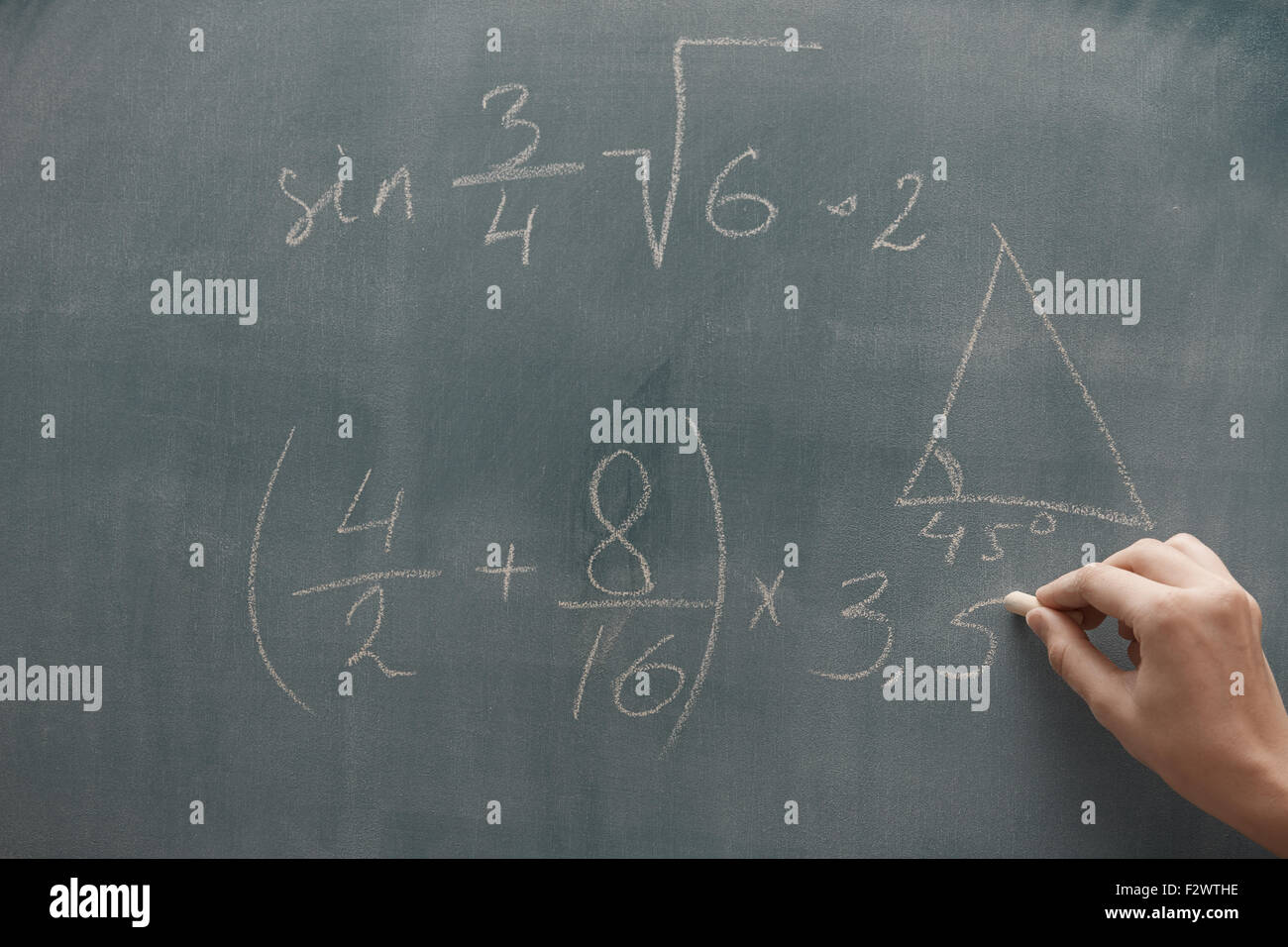 Hand of student studying mathematics and writing on a blackboard Stock ...