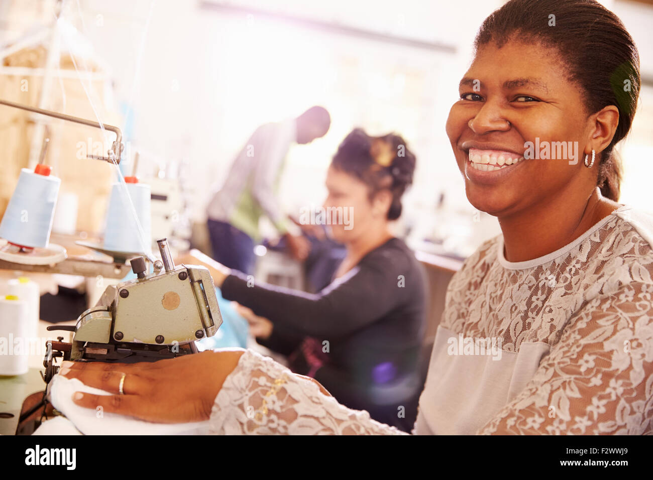 Smiling woman sewing at a community workshop, South Africa Stock Photo ...