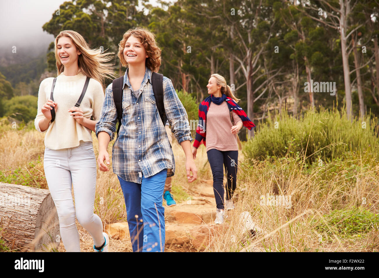 Happy family walking out of a forest Stock Photo - Alamy