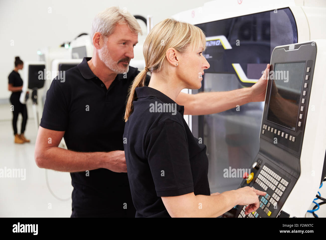 Two Engineers Operating CNC Machinery On Factory Floor Stock Photo - Alamy