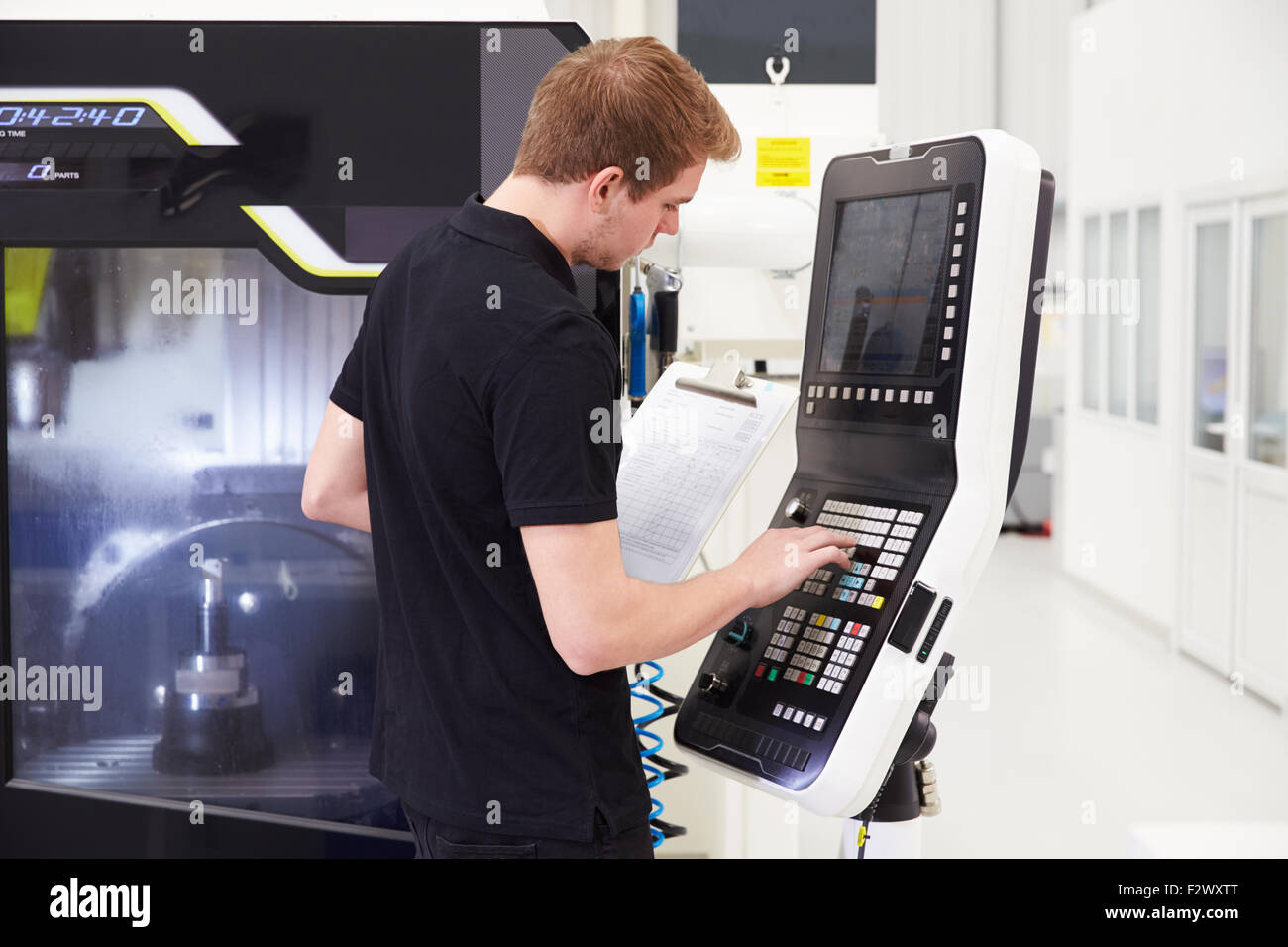 Male Engineer Operating CNC Machinery On Factory Floor Stock Photo - Alamy
