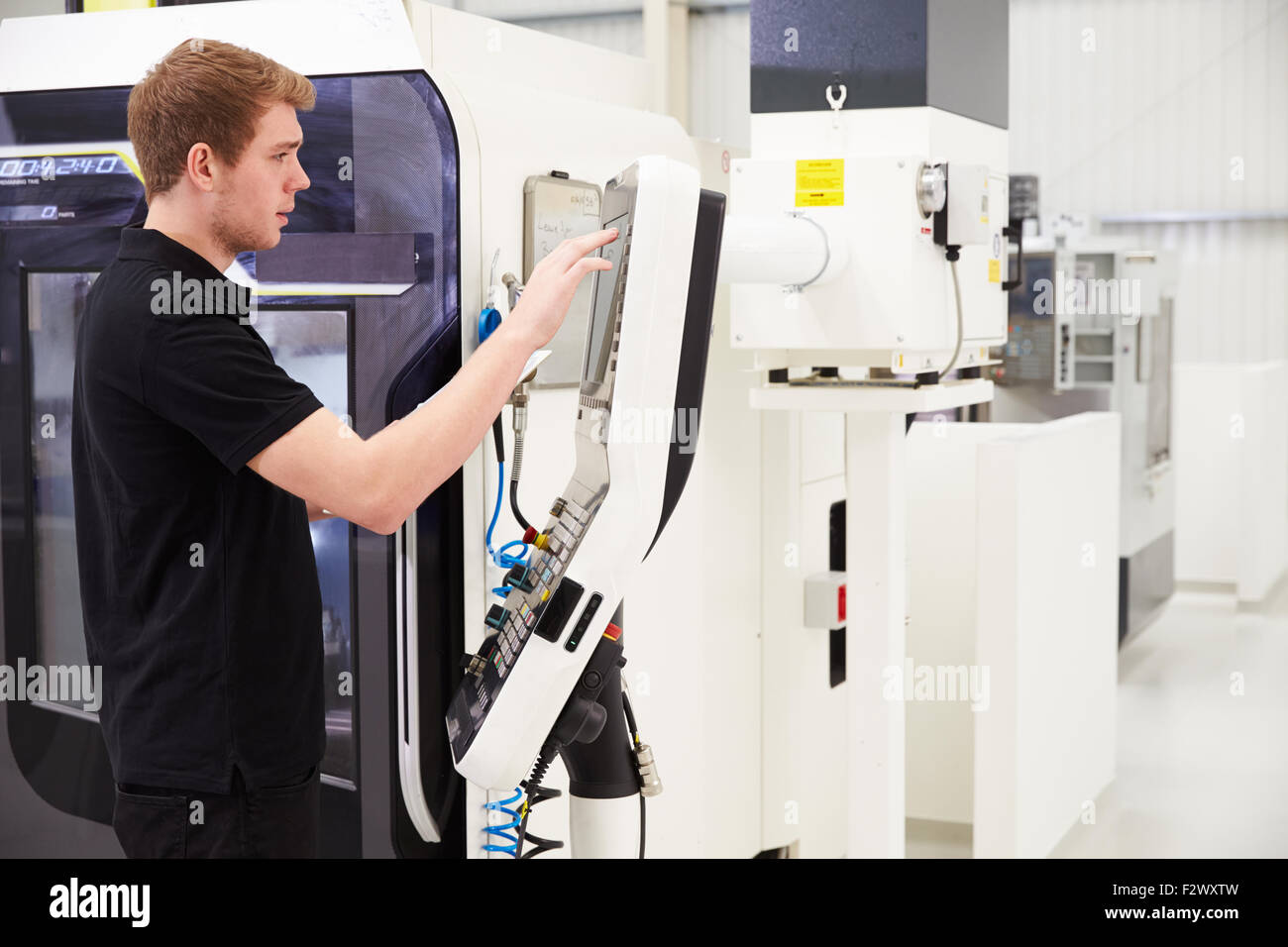 Male Engineer Operating CNC Machinery On Factory Floor Stock Photo - Alamy