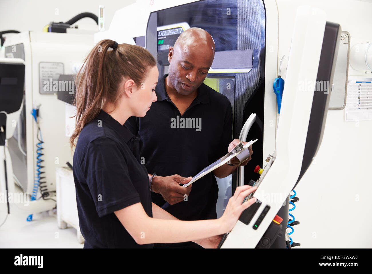 Black female factory engineer teaching hi-res stock photography and ...