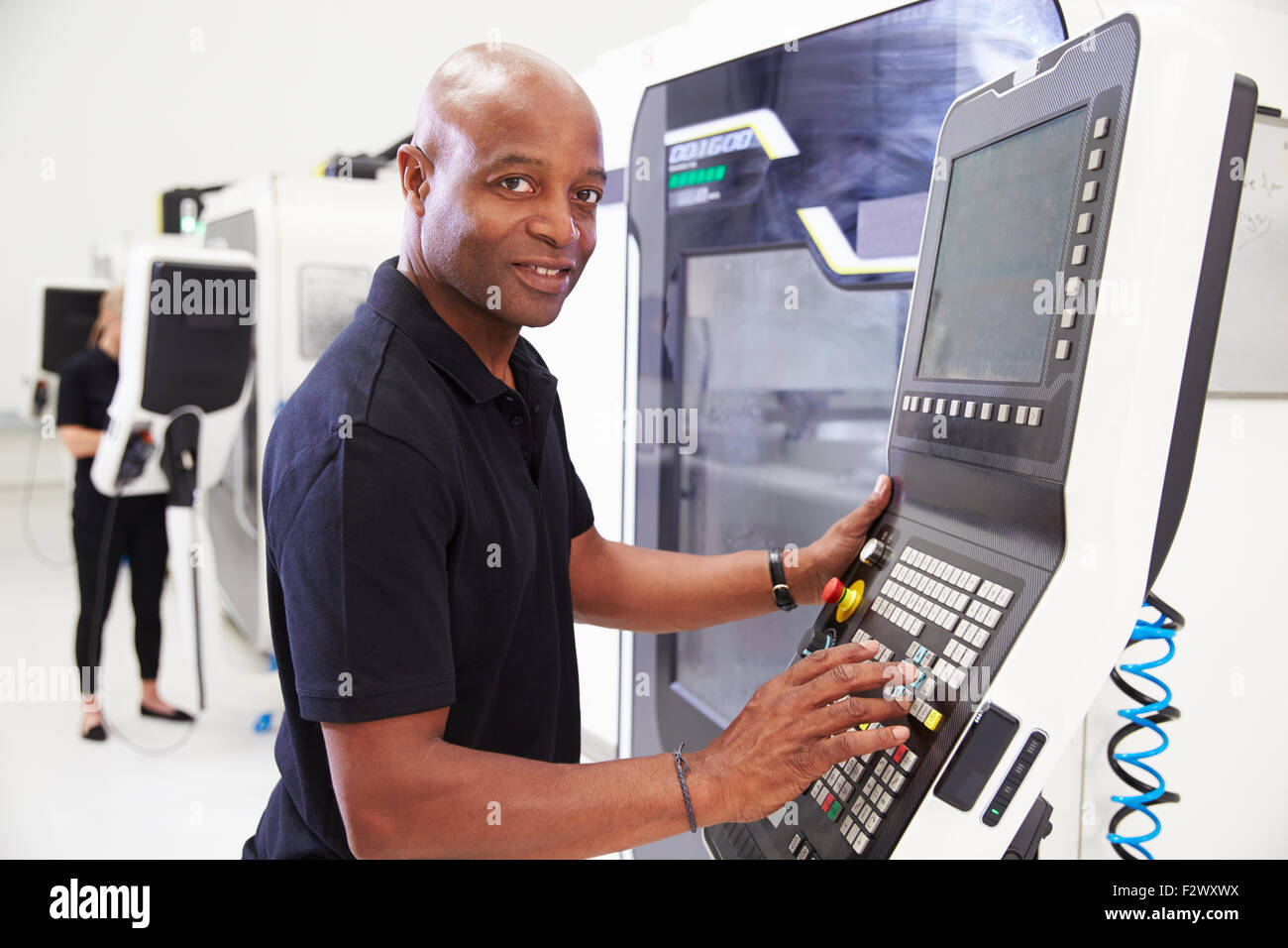 Portrait Of Male Engineer Operating CNC Machinery In Factory Stock ...