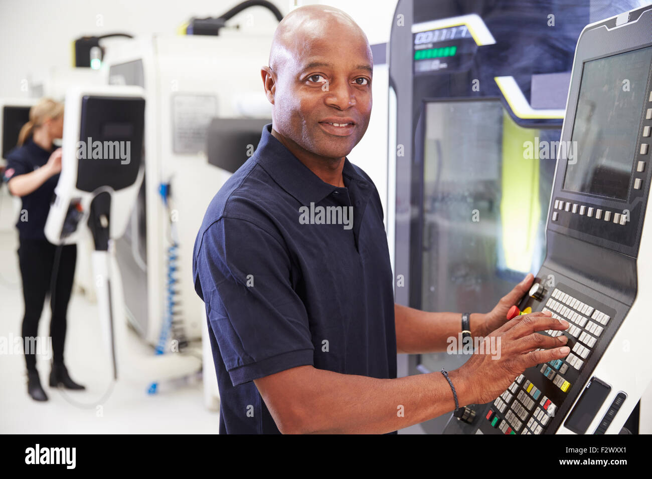 Portrait Of Male Engineer Operating CNC Machinery In Factory Stock ...