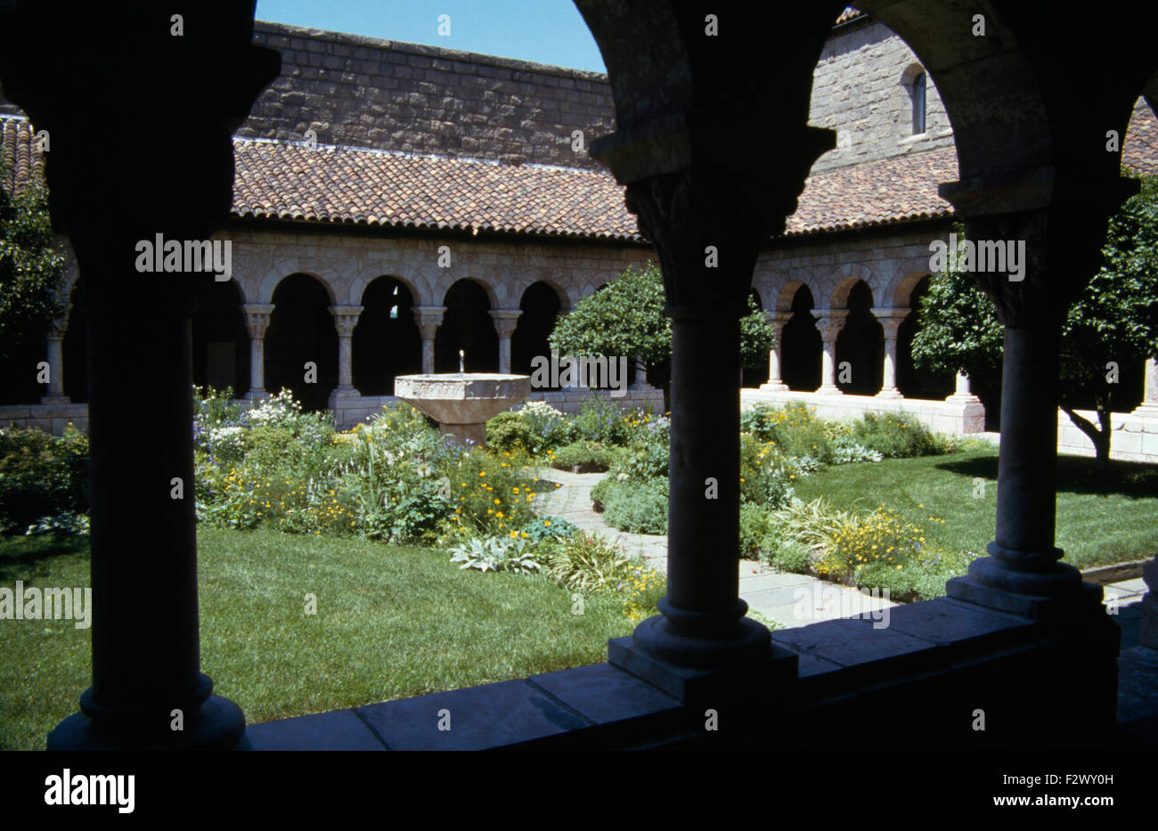 Path through borders and small lawns to fountain in cloistered ...
