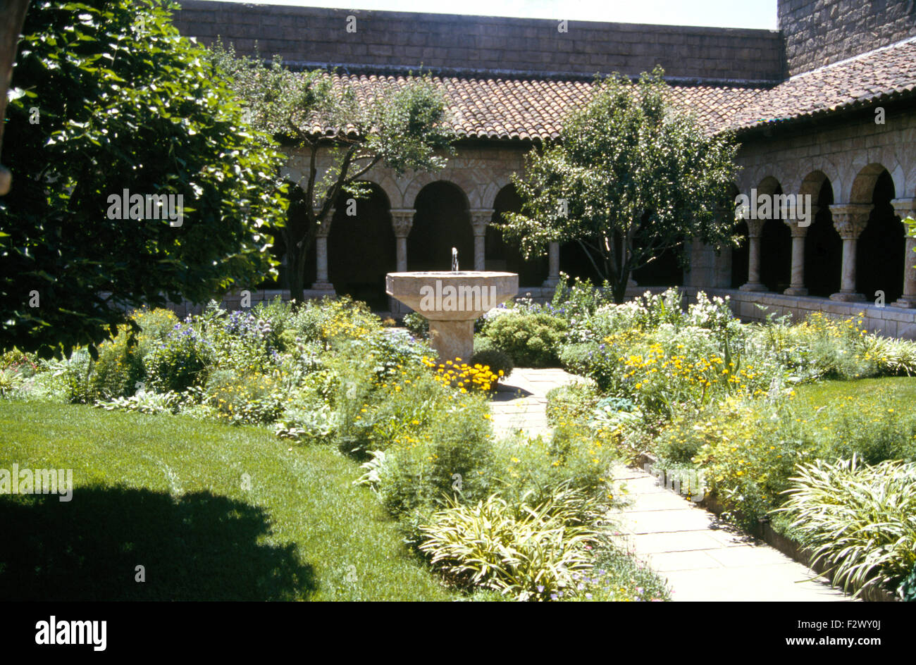 Path through borders and small lawns to fountain in cloistered ...